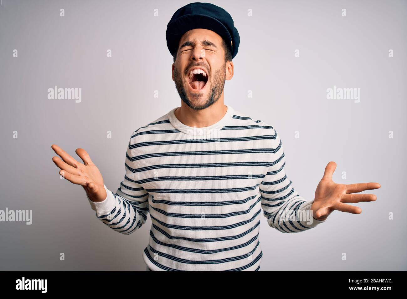 Young handsome sailor man with beard wearing navy striped uniform and ...