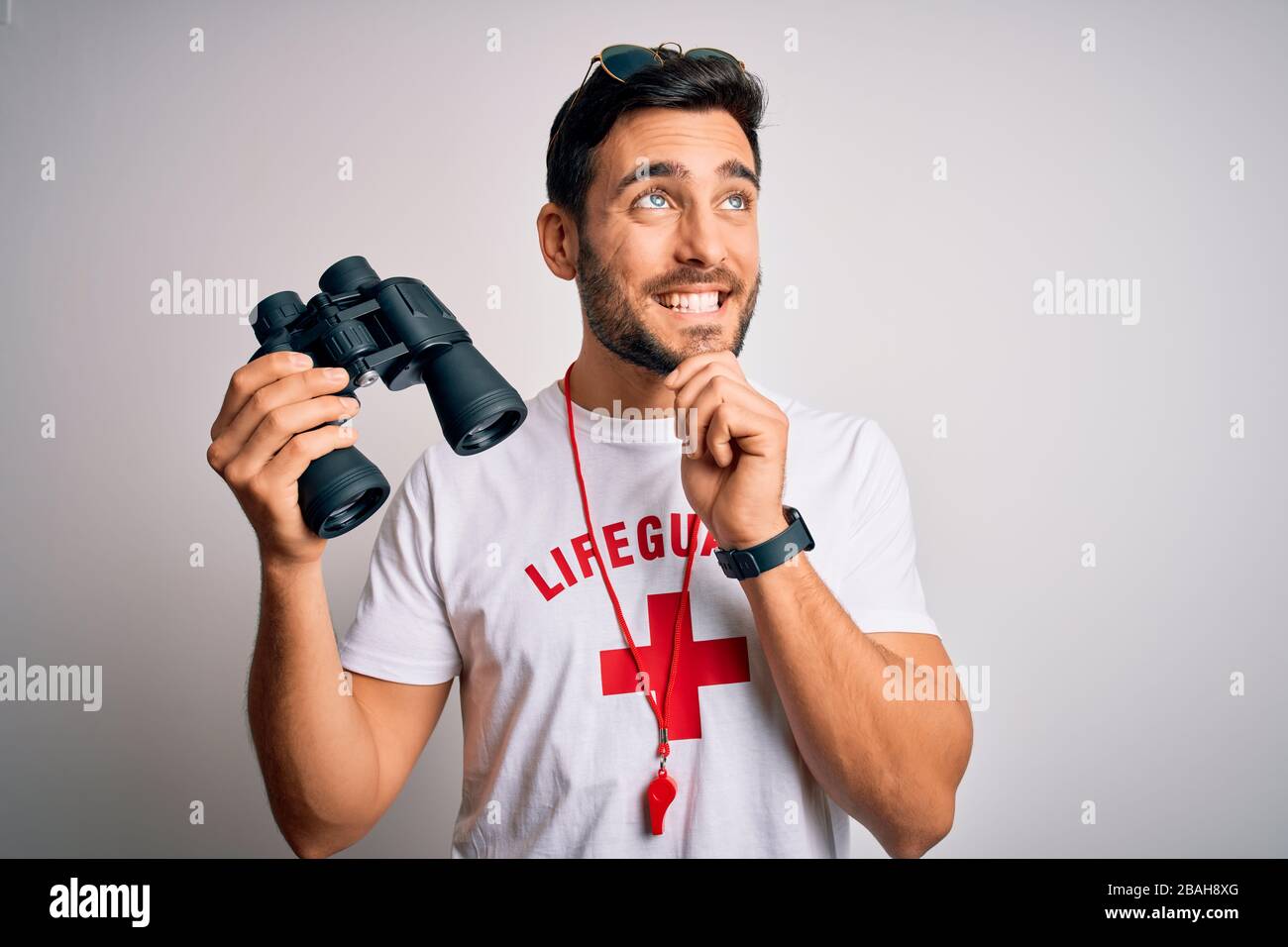 Young lifeguard man with beard wearing t-shirt with red cross and ...