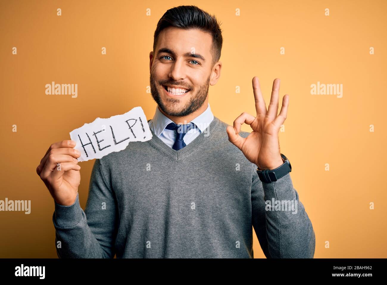 Young overworked business man asking for help holding paper over yellow ...