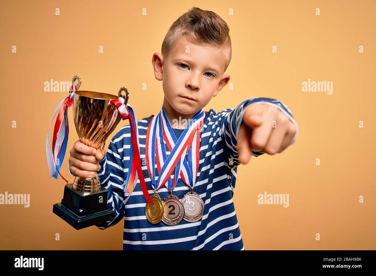 Young little caucasian kid wearing winner medals and victory award ...