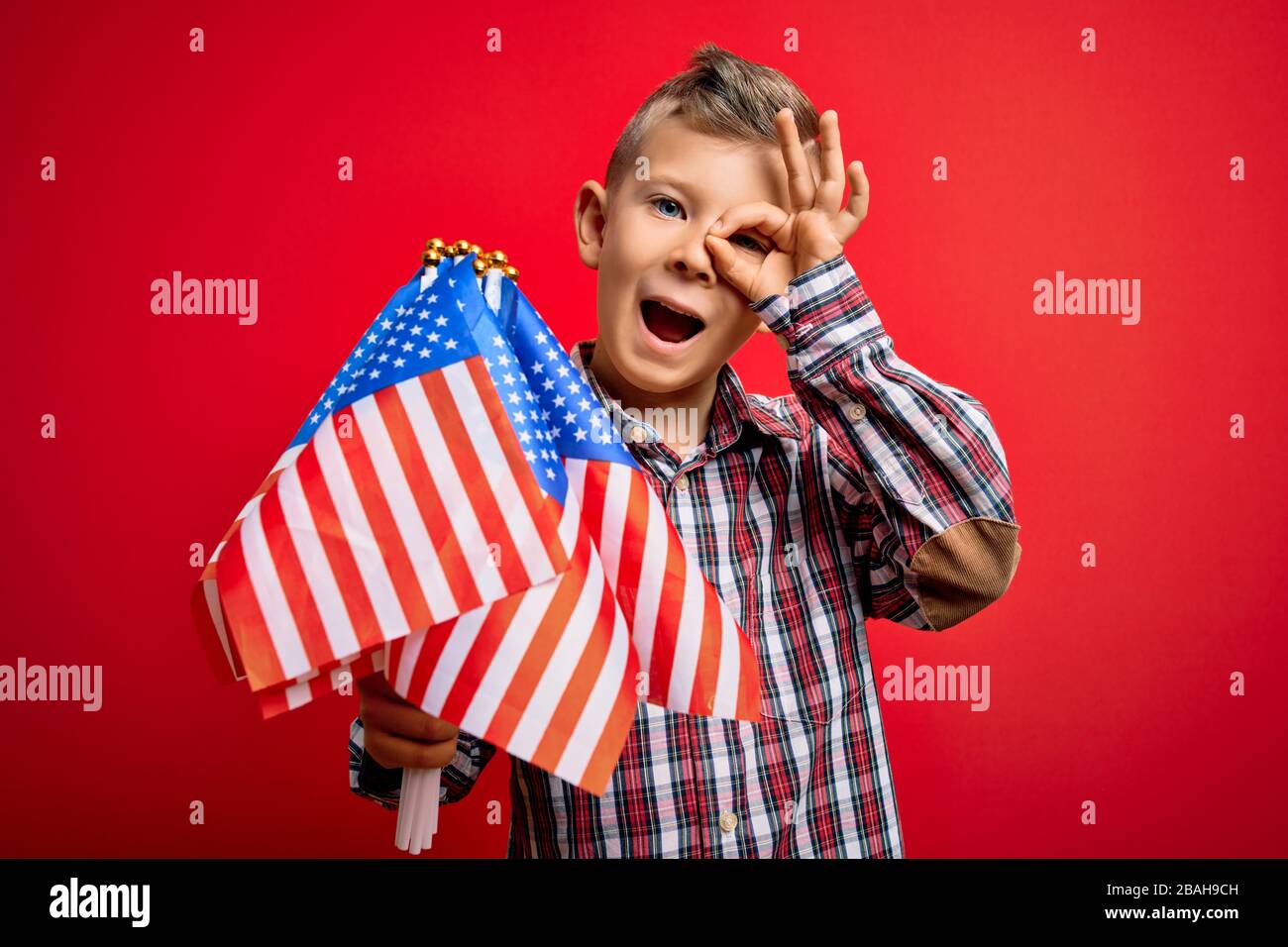 Young little american patriotic caucasian kid holding flag of USA over ...