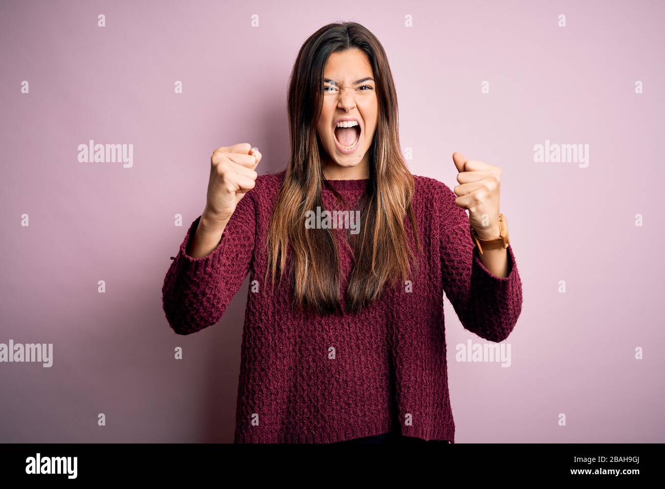 Young beautiful girl wearing casual sweater over isolated pink ...