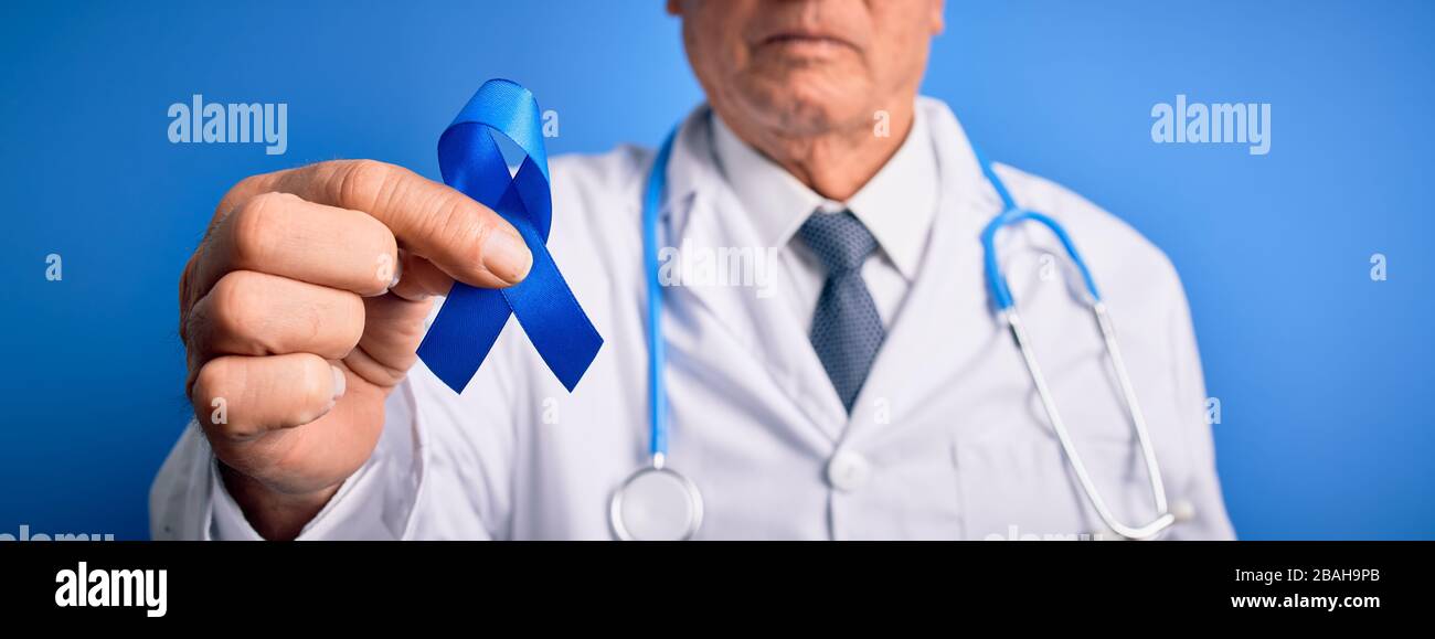 Grey haired senior doctor man holding colon cancer awareness blue ...