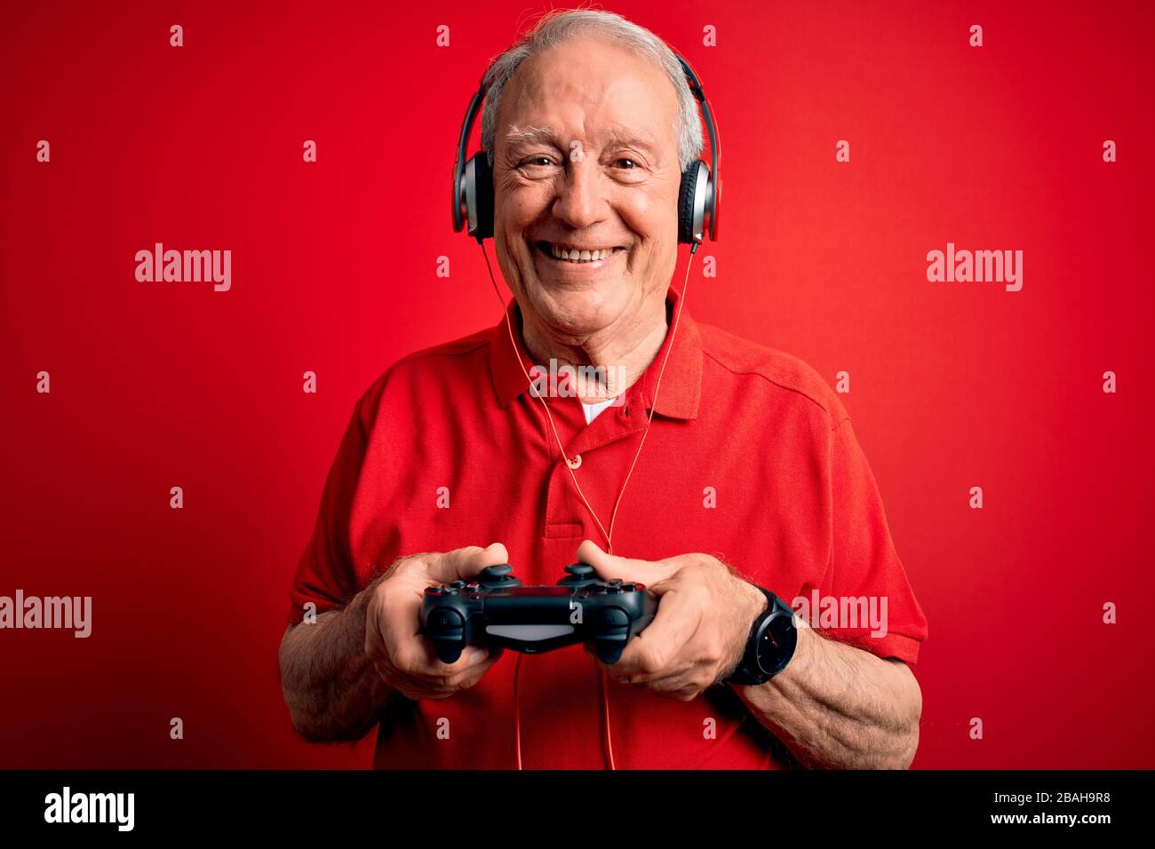Senior grey haired gamer man playing video games using gamepad joystick ...