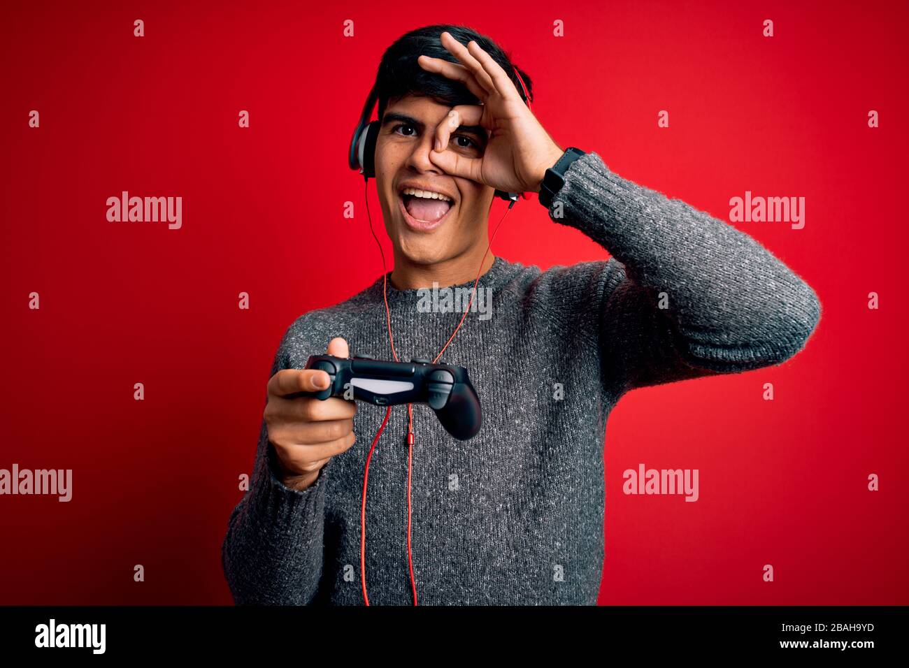 Young handsome gamer man playing video game using joystick and ...