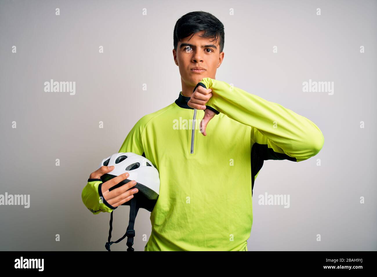 Young handsome cyclist man holding security bike helmet over isolated ...