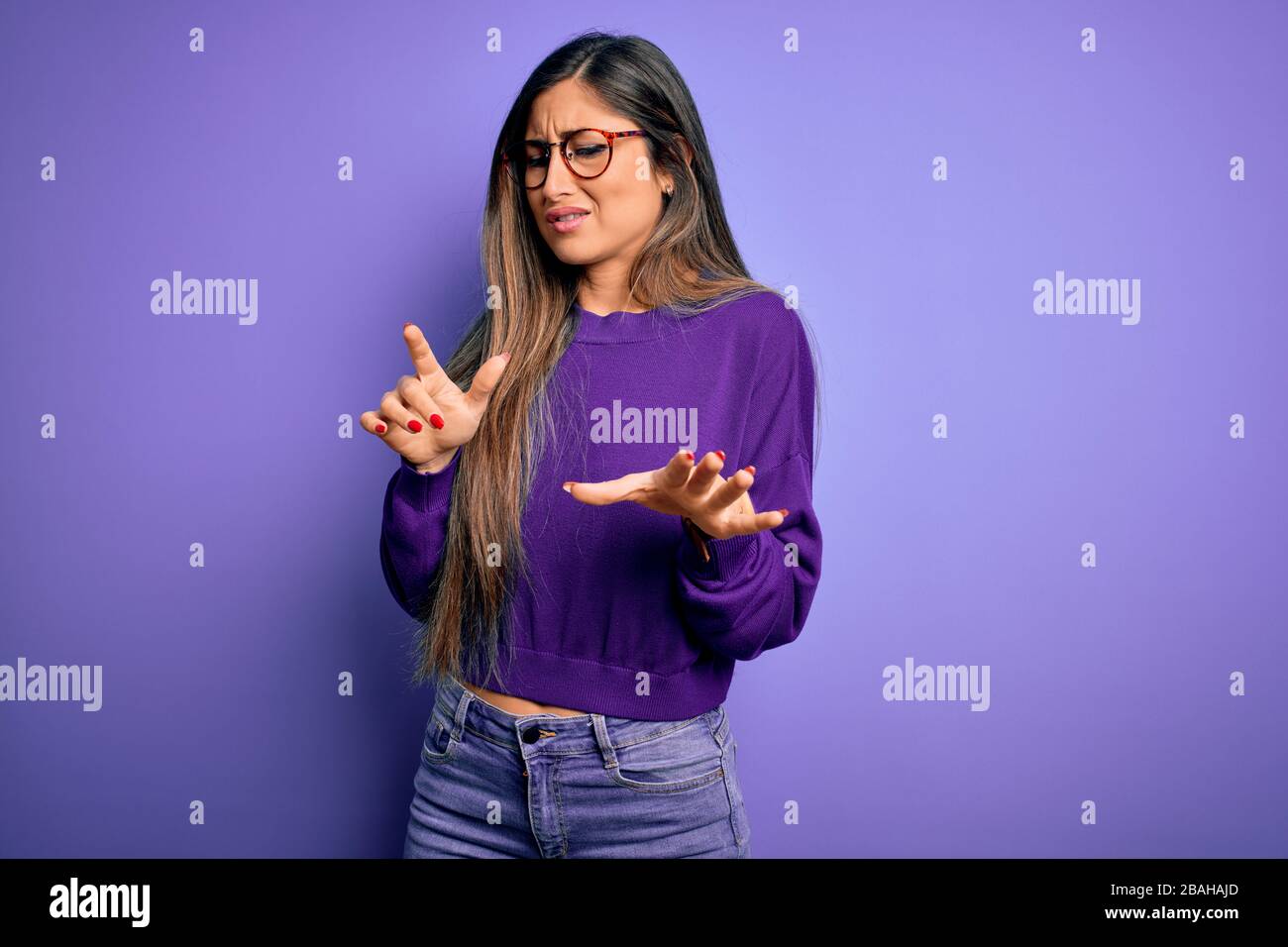 Young beautiful smart woman wearing glasses over purple isolated ...