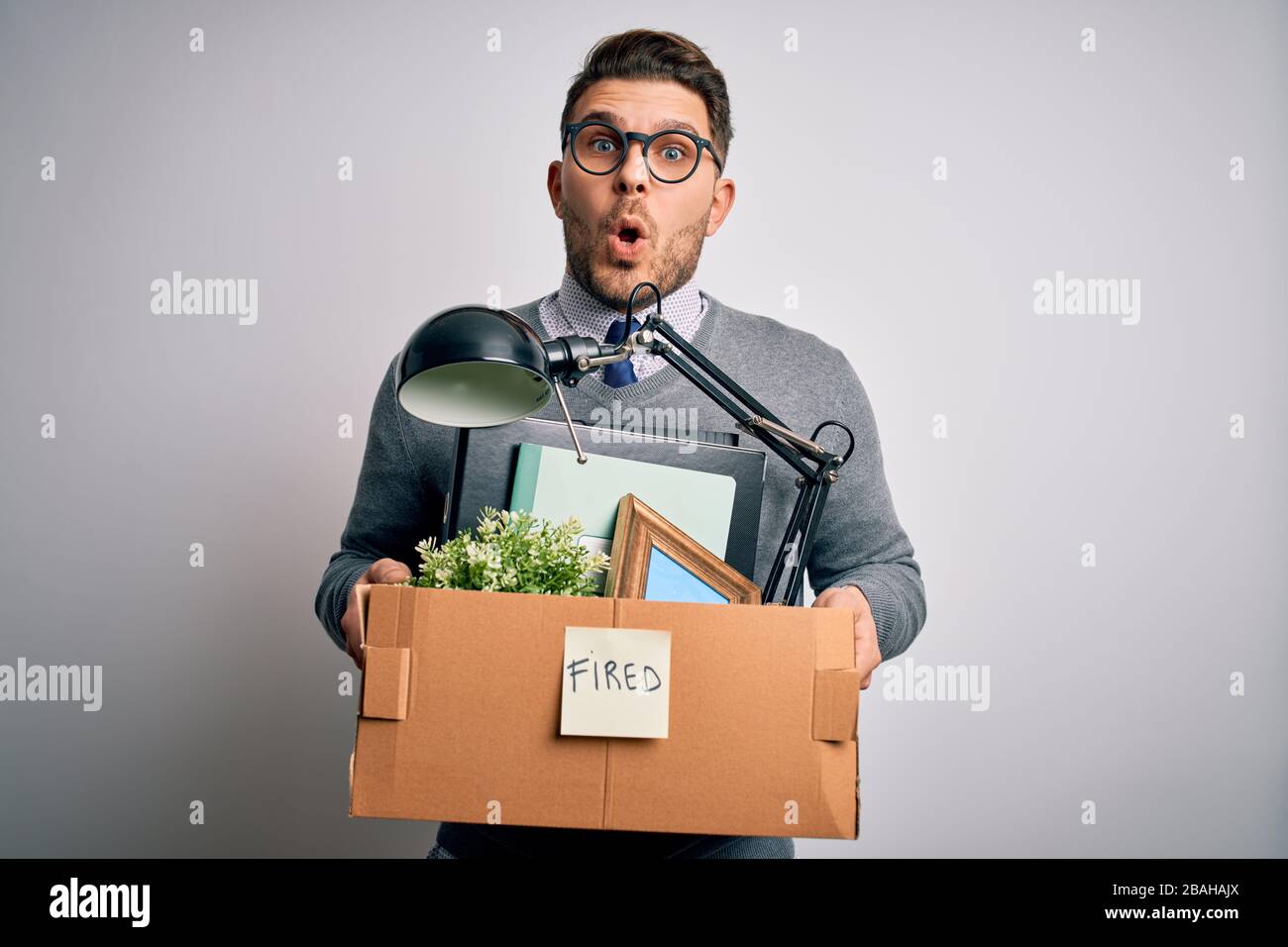 Young business man with blue eyes holding box from the office beeing ...
