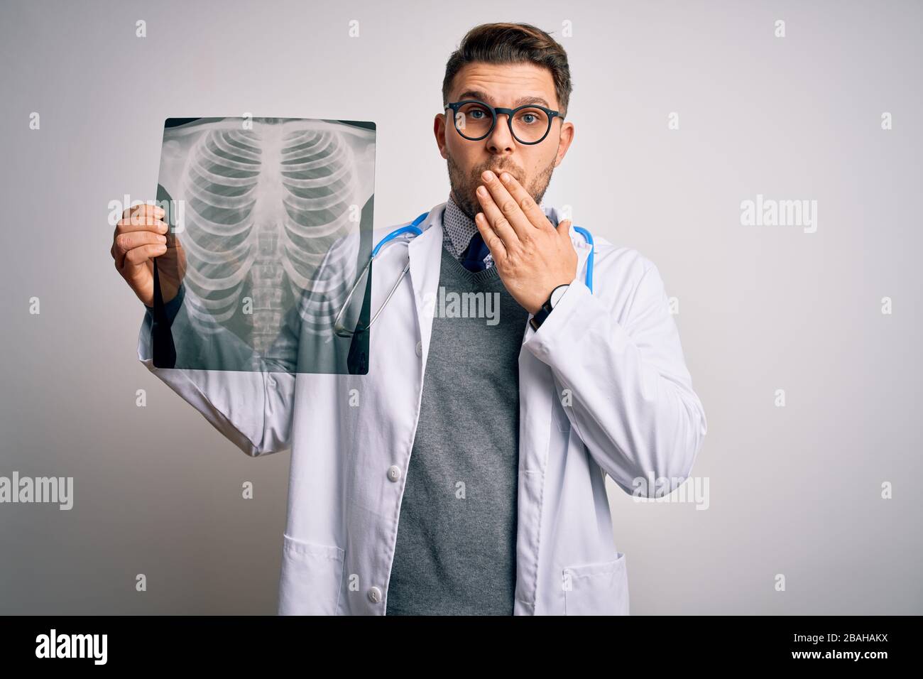 Young doctor man wearing medical coat looking at chest scan radiography ...