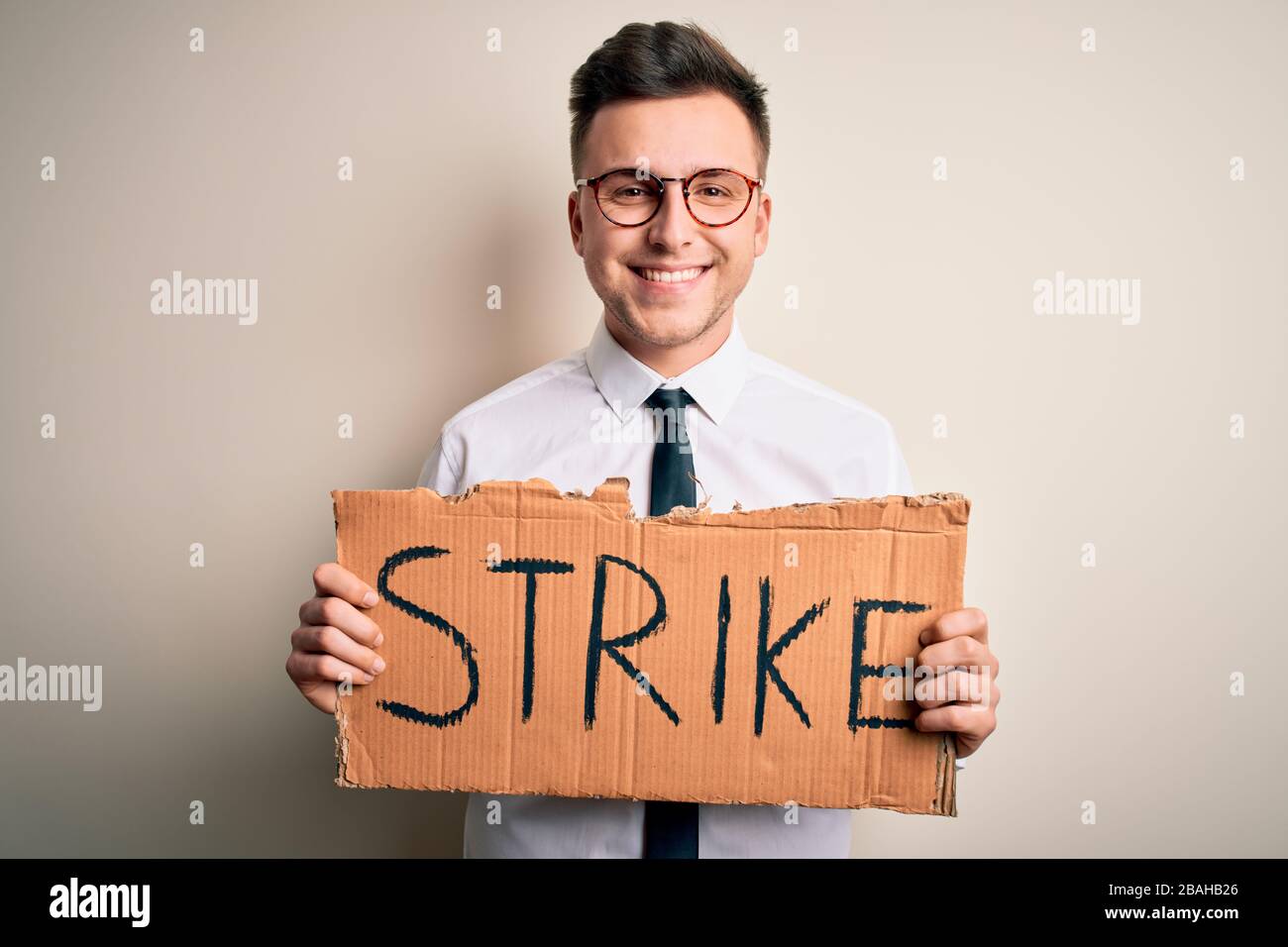 Young handsome caucasian business man holding protest banner on job ...