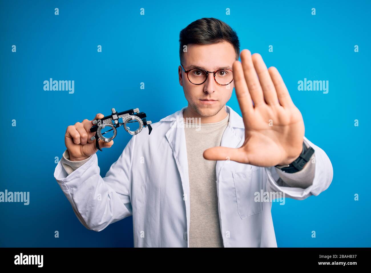 Young handsome professional optic man holding optometrical glasses over ...