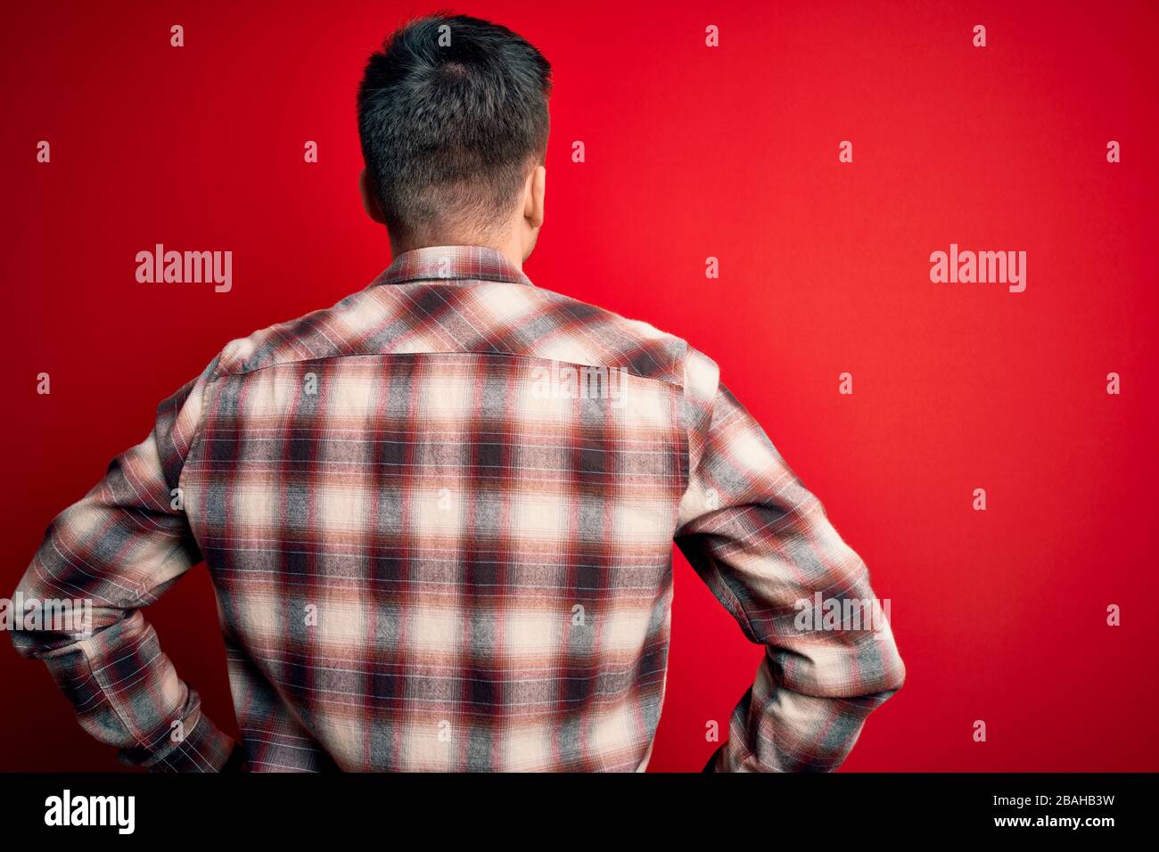 Young handsome caucasian man wearing casual modern shirt over red ...