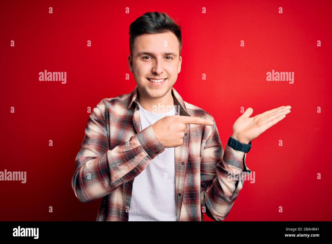 Young handsome caucasian man wearing casual modern shirt over red ...