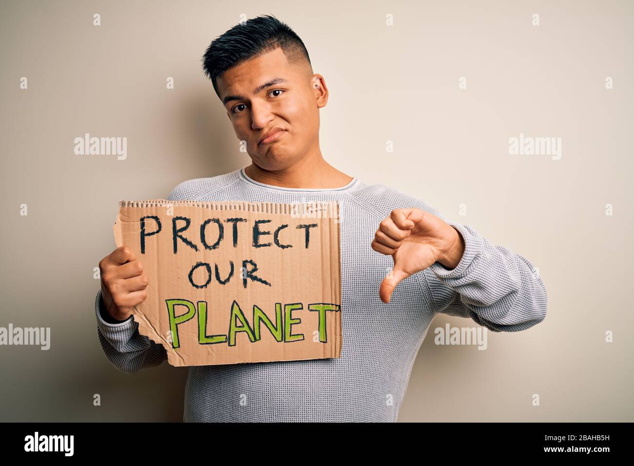 Young handsome activist latin man holding banner asking to protect our ...