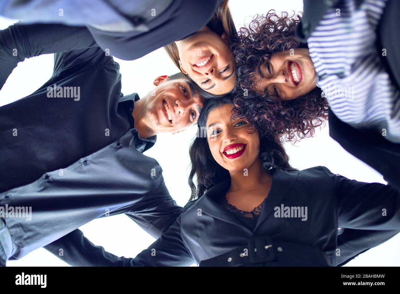 Group of business workers smiling happy. Standing with heads together ...