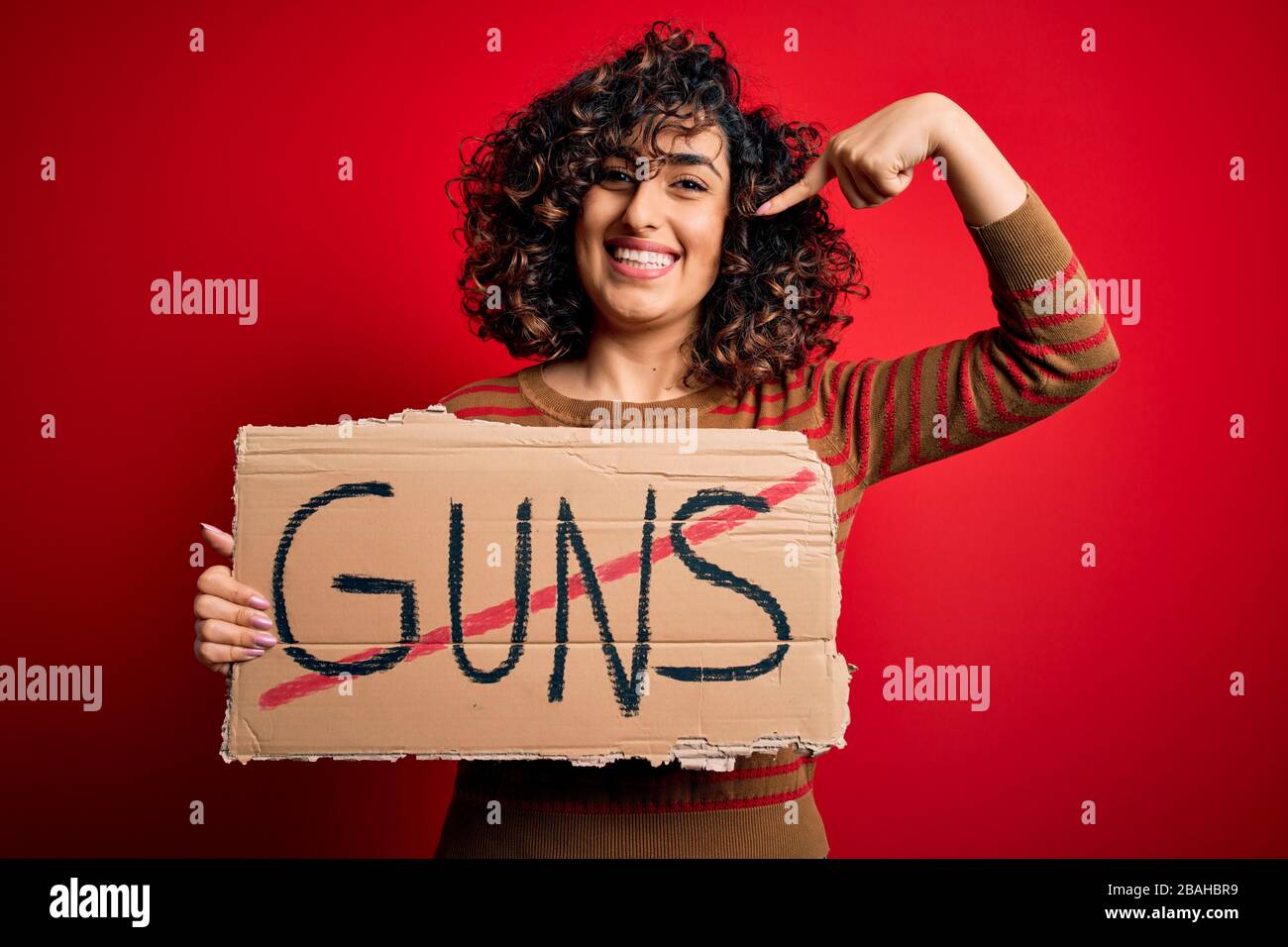 Young beautiful arab woman asking for peace holding banner with ...