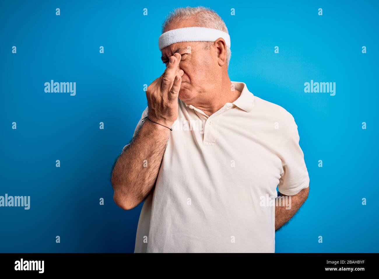 Middle age hoary sportsman doing sport wearing sportswear over isolated ...