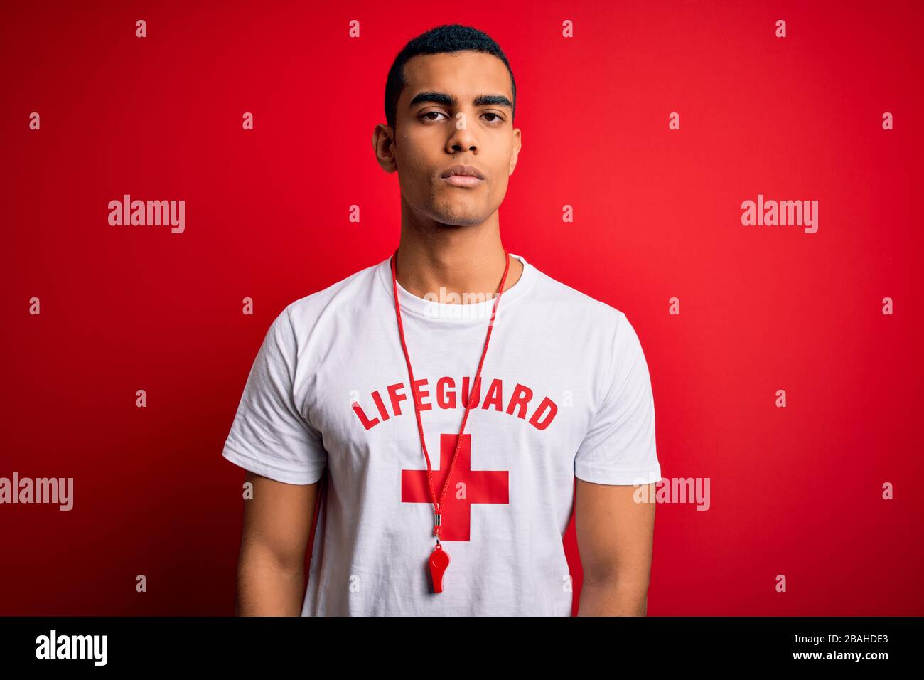 Young handsome african american lifeguard man wearing t-shirt with red ...