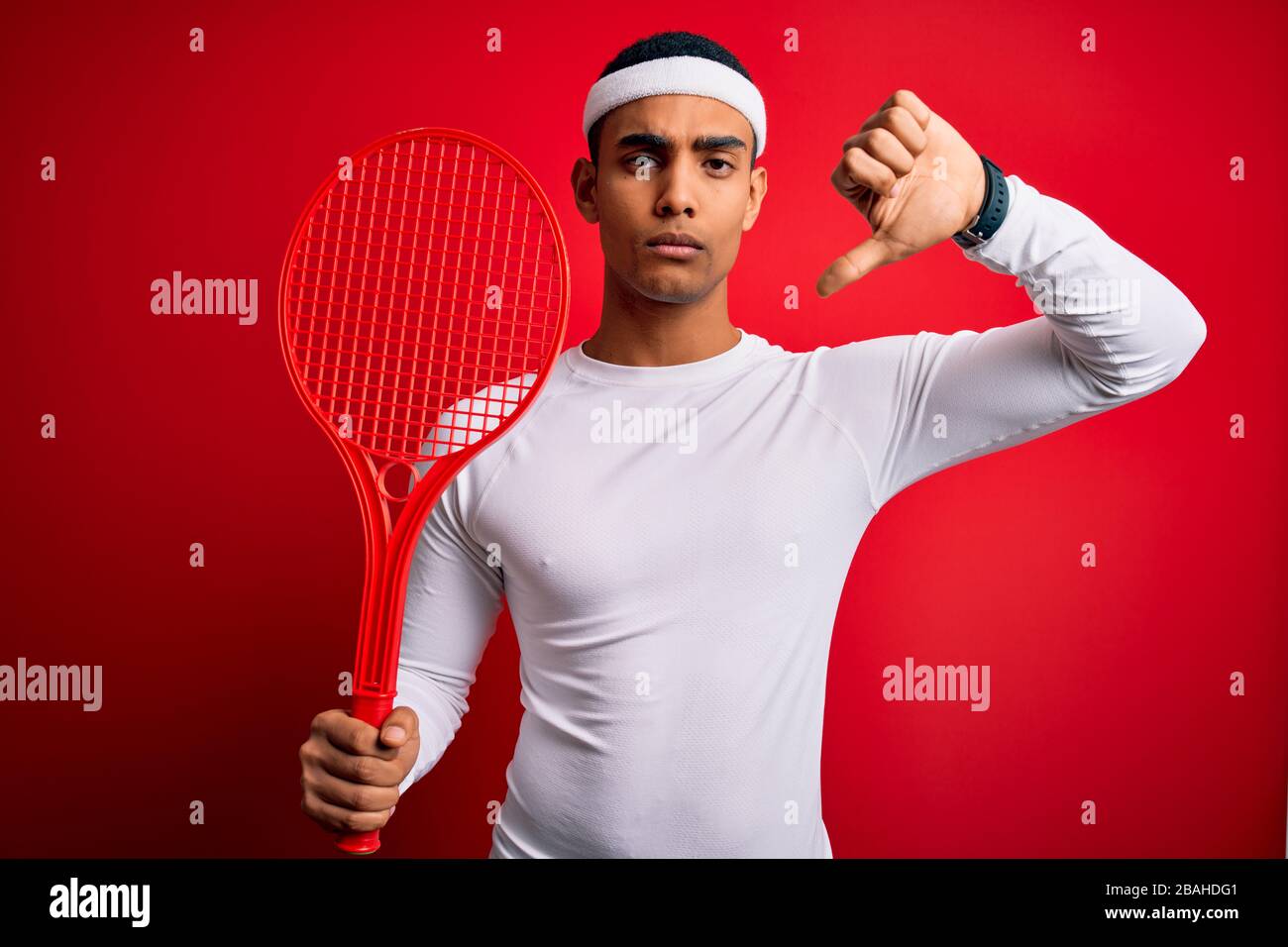 Young handsome african american sportsman playing tennis using racket ...