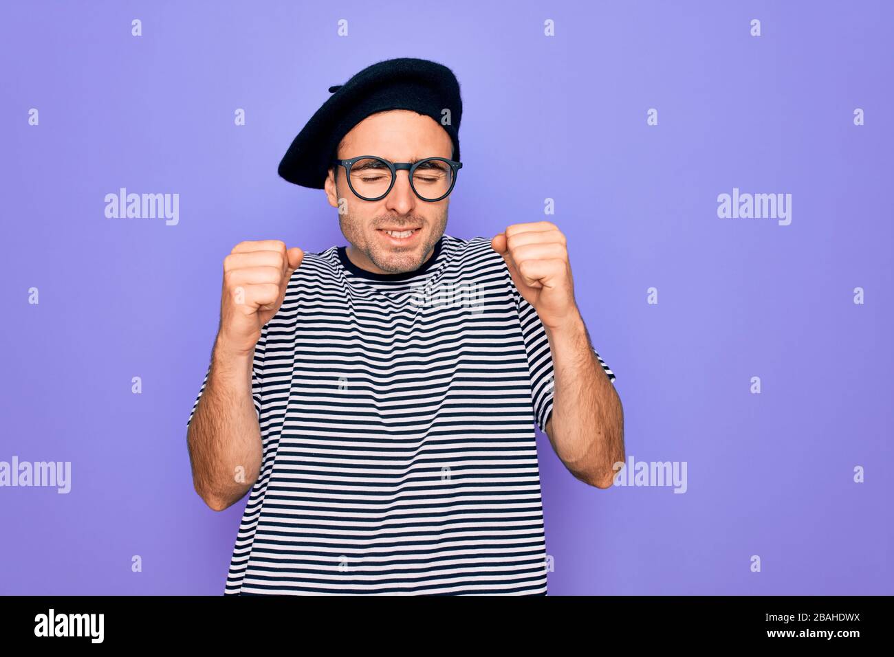 Handsome man with blue eyes wearing striped t-shirt and french beret ...