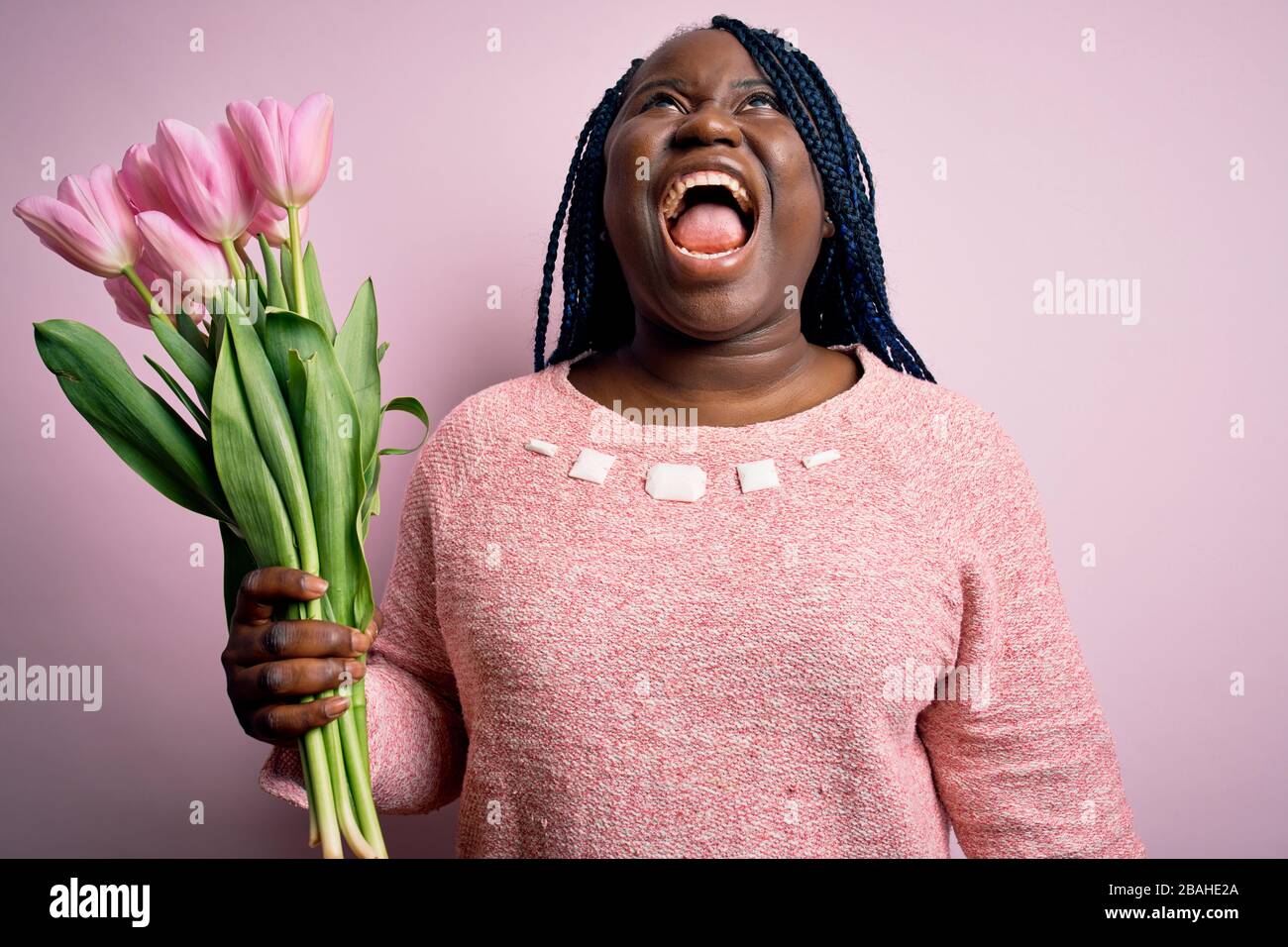 Young african american plus size woman with braids holding bouquet of ...