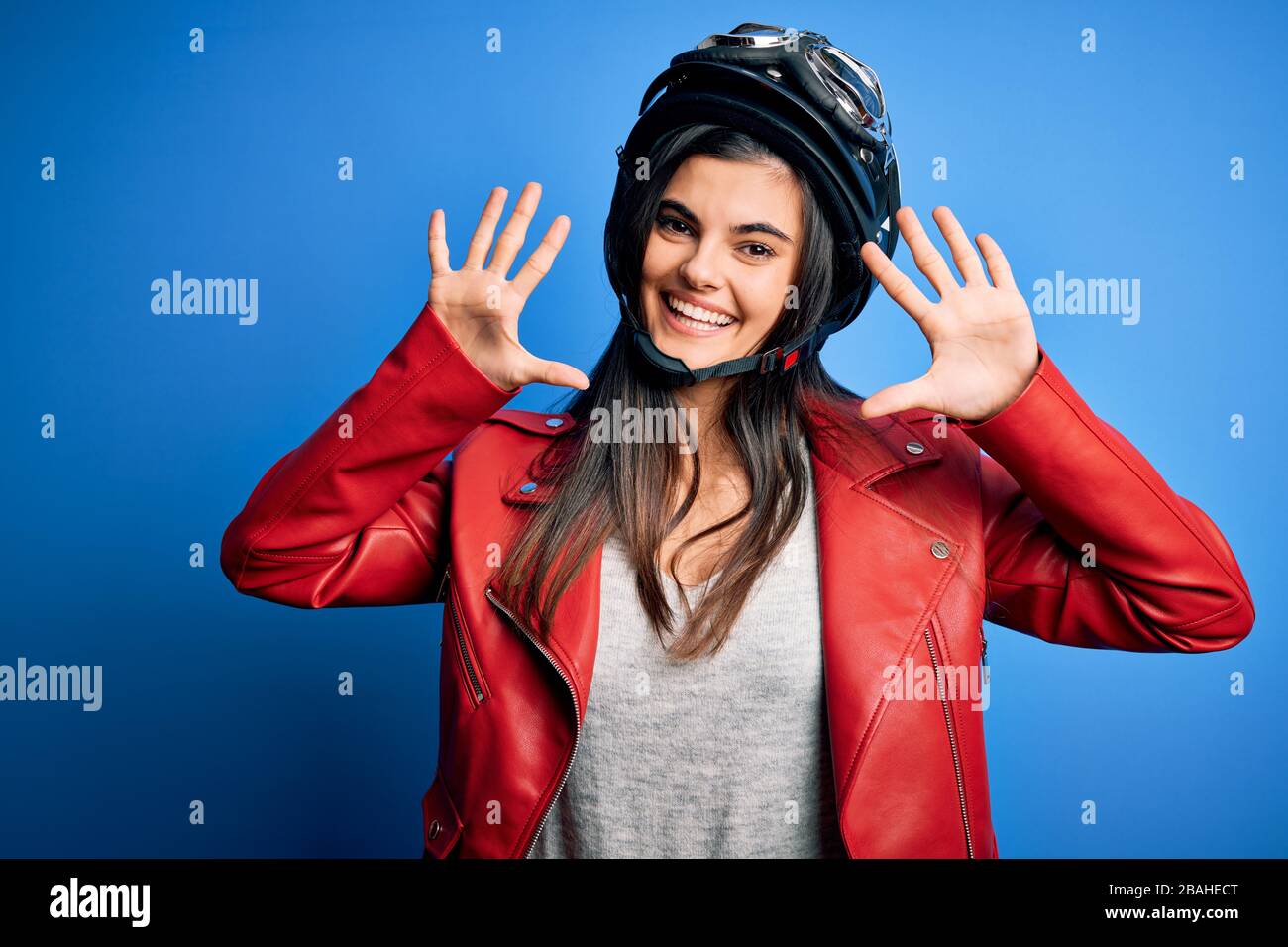 Young beautiful brunette motorcycliste woman wearing motorcycle helmet ...
