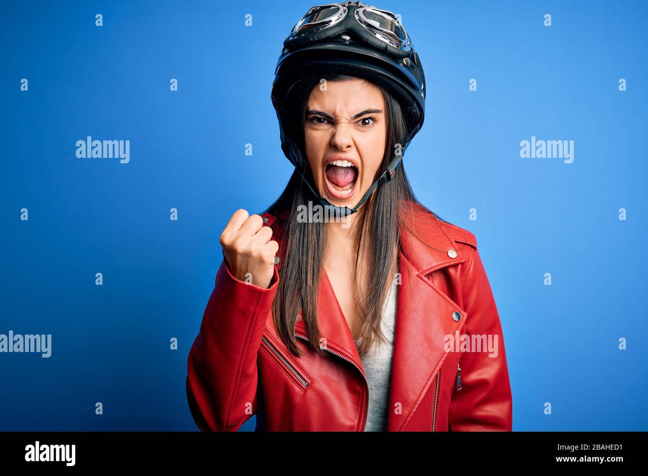 Young beautiful brunette motorcycliste woman wearing motorcycle helmet ...