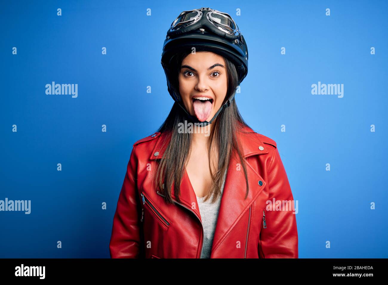 Young beautiful brunette motorcycliste woman wearing motorcycle helmet ...