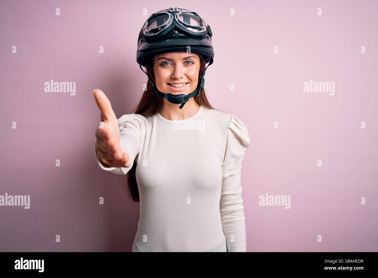 Young beautiful motorcyclist woman with blue eyes wearing moto helmet ...