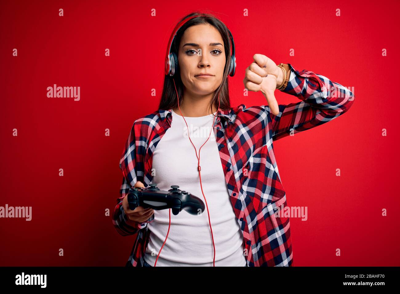 Young beautiful brunette gamer woman playing video game using joystick ...