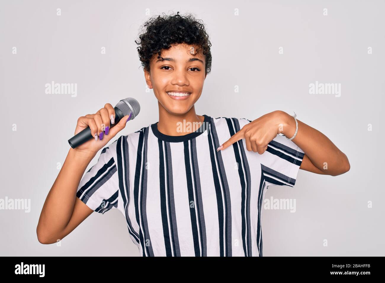 Beautiful african american afro singer woman singing using microphone ...