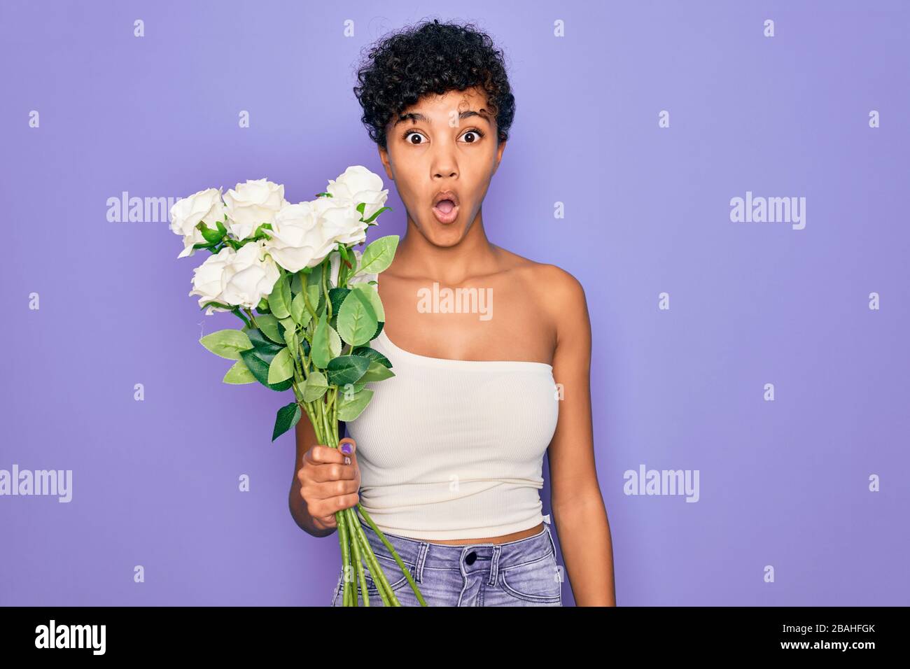 Beautiful african american afro woman holding bouquet of white flowers ...