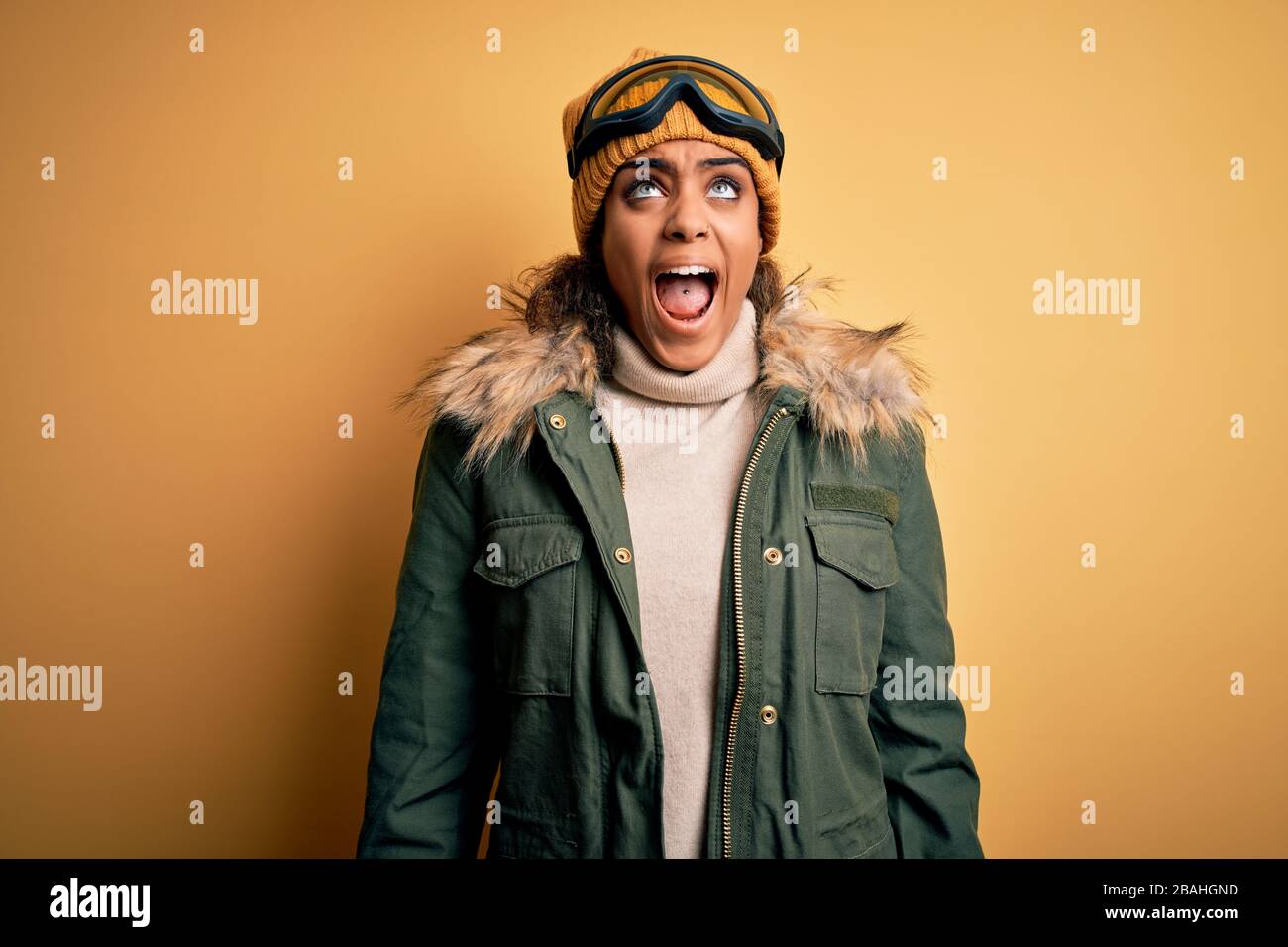Young african american afro skier girl wearing snow sportswear and ski ...