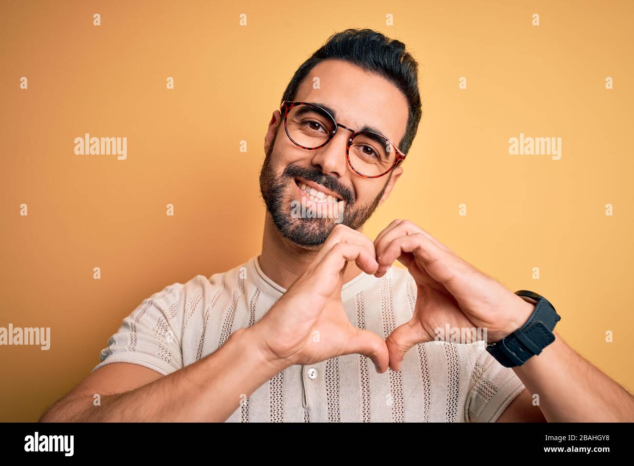 Young handsome man with beard wearing casual t-shirt and glasses over ...