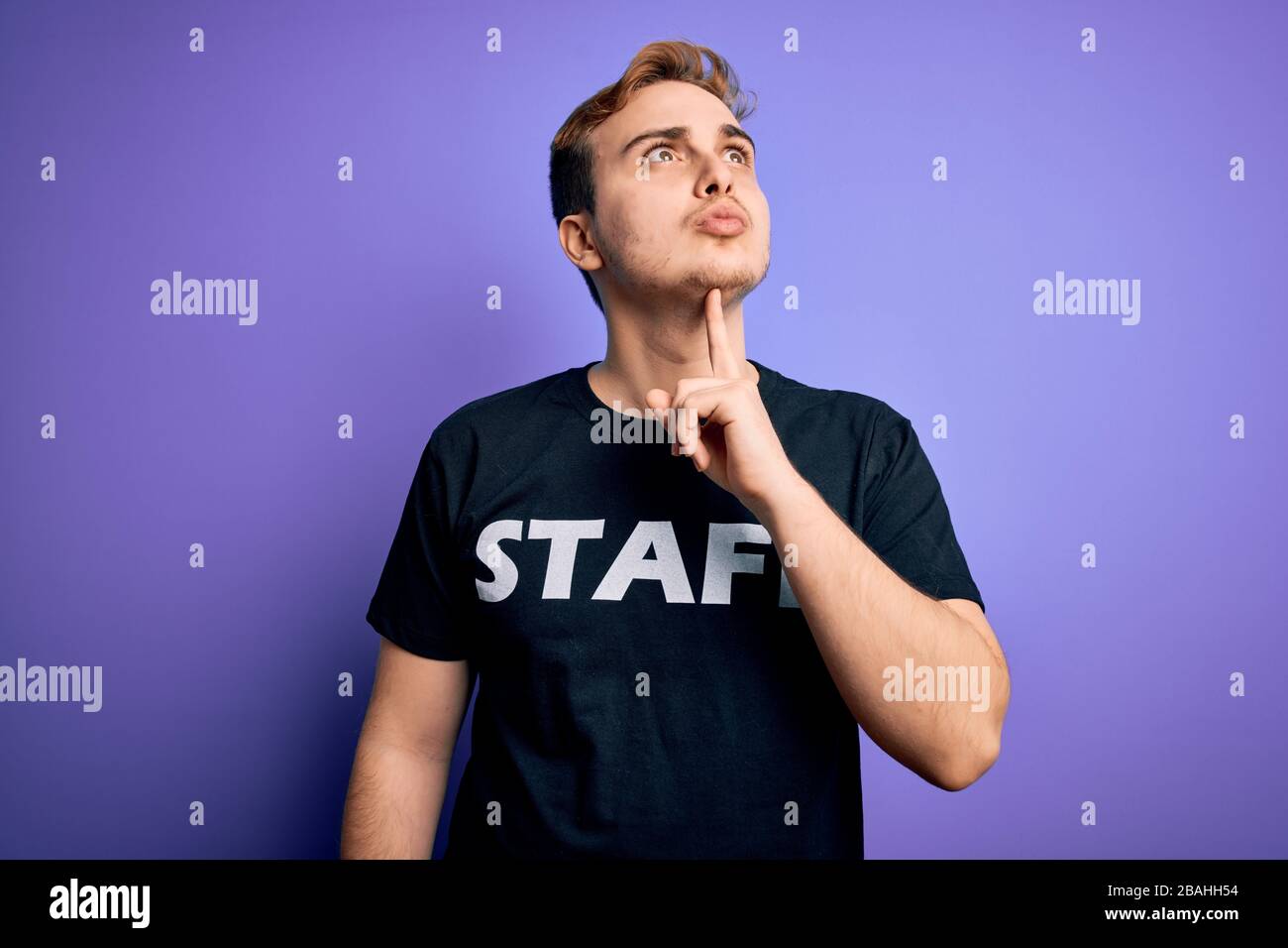 Young handsome redhead worker man wearing staff t-shirt uniform over ...