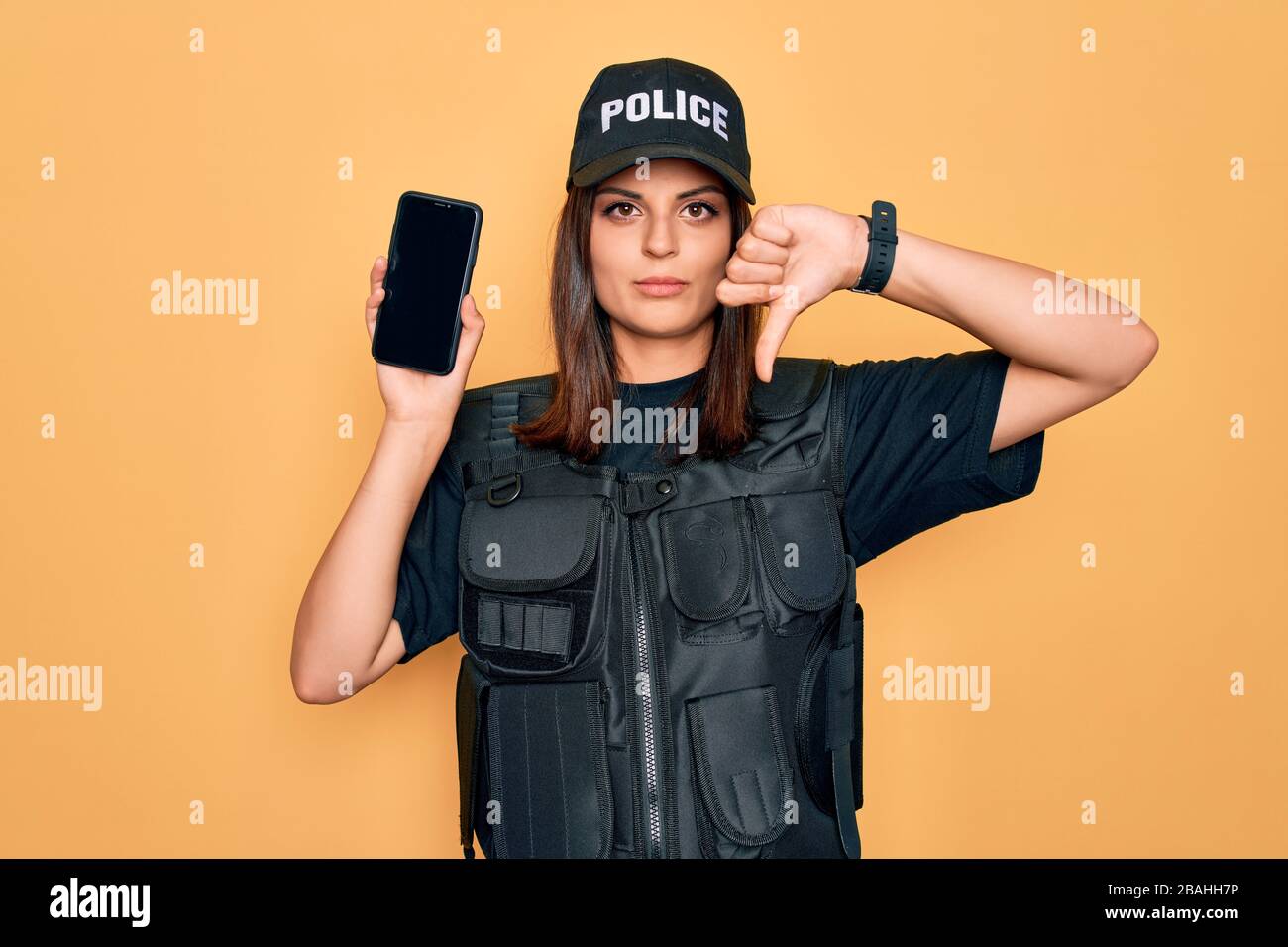 Beautiful brunette policewoman wearing police uniform holding ...