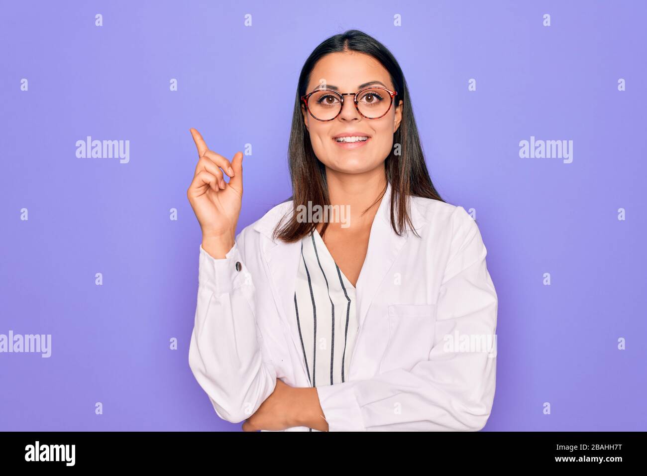 Young beautiful brunette psychologist woman wearing coat and glasses ...