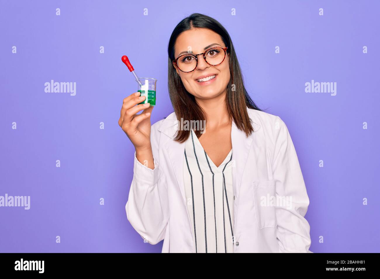 Young beautiful brunette scientist woman wearing coat and glasses ...