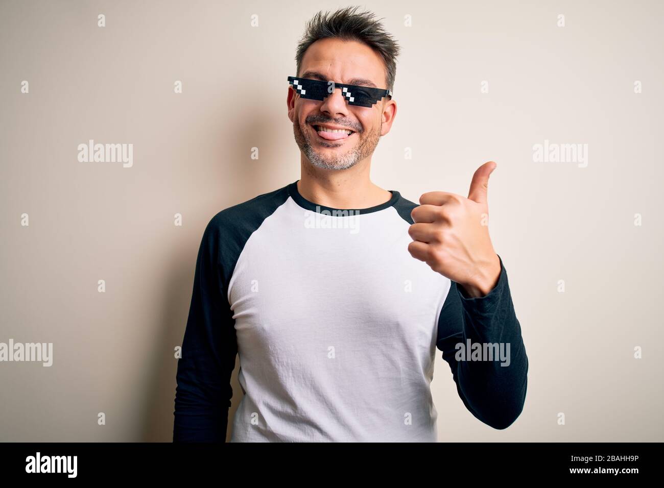 Young Handsome Man Wearing Funny Thug Life Sunglasses Meme Over White