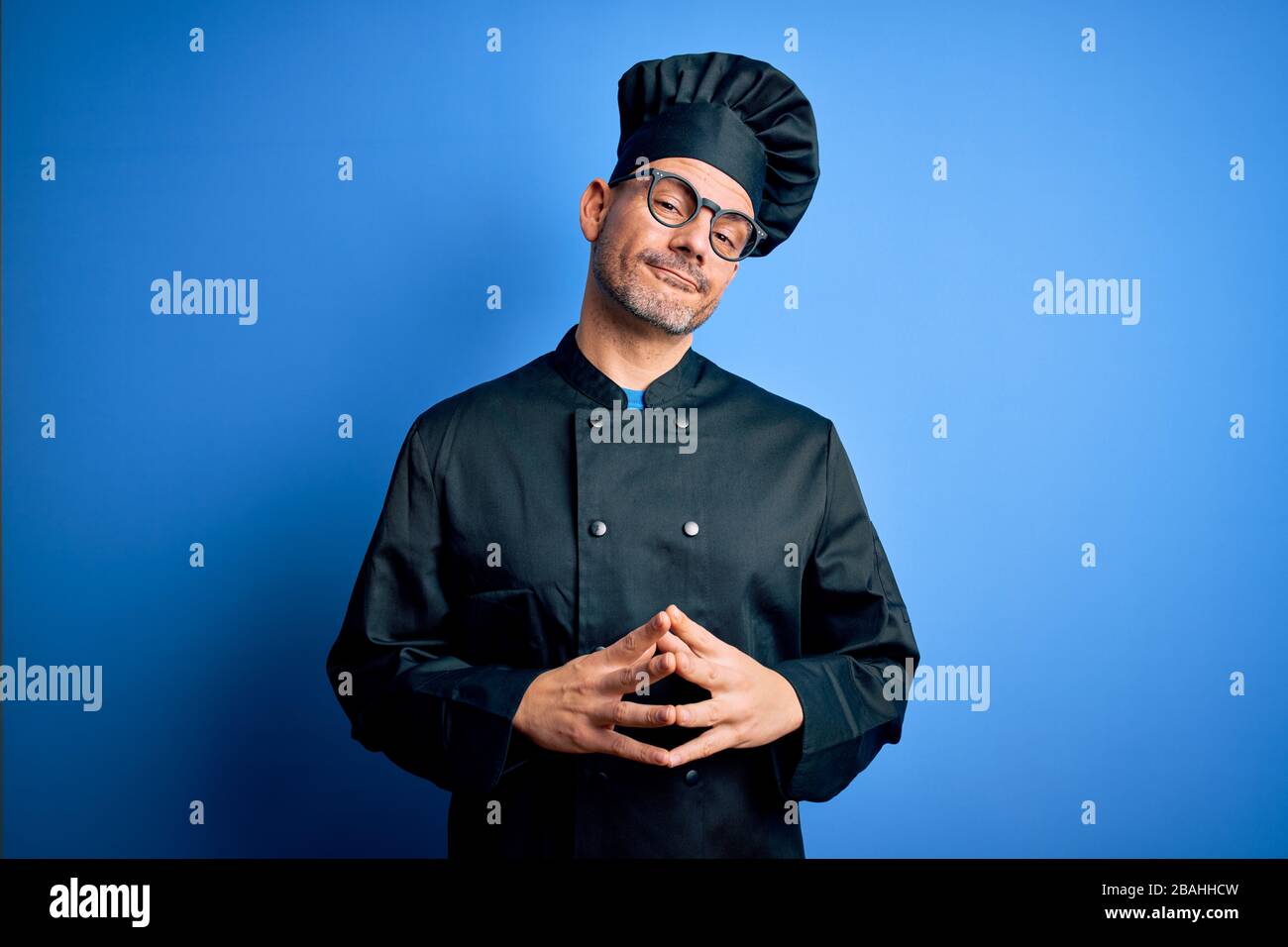 Young handsome chef man wearing cooker uniform and hat over isolated ...