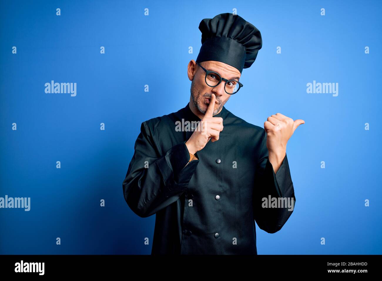 Young handsome chef man wearing cooker uniform and hat over isolated ...