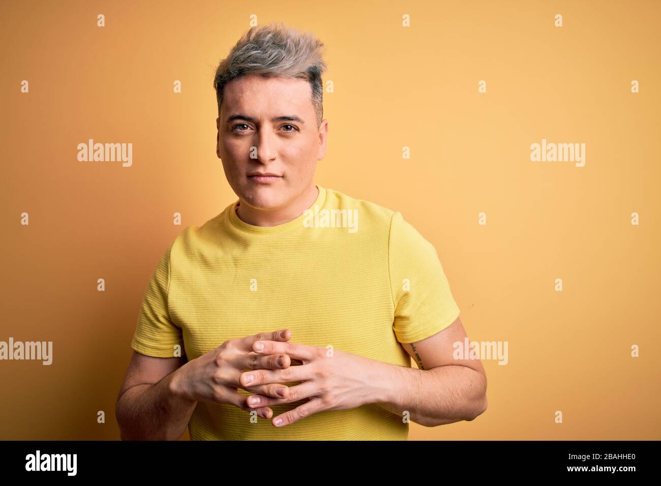 Young handsome modern man wearing yellow shirt over yellow isolated ...