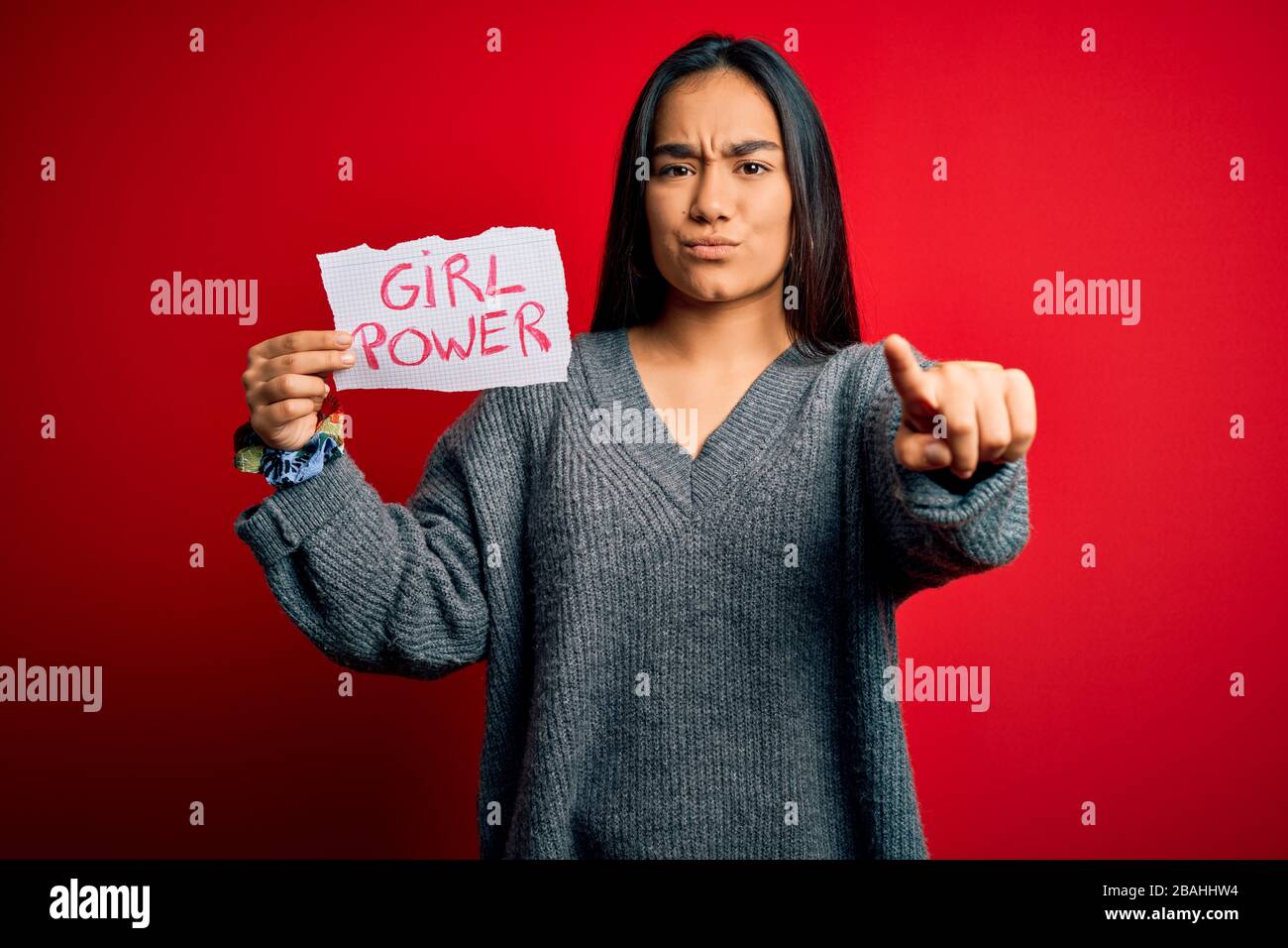 Young beautiful asian woman holding banner with girl power message over ...