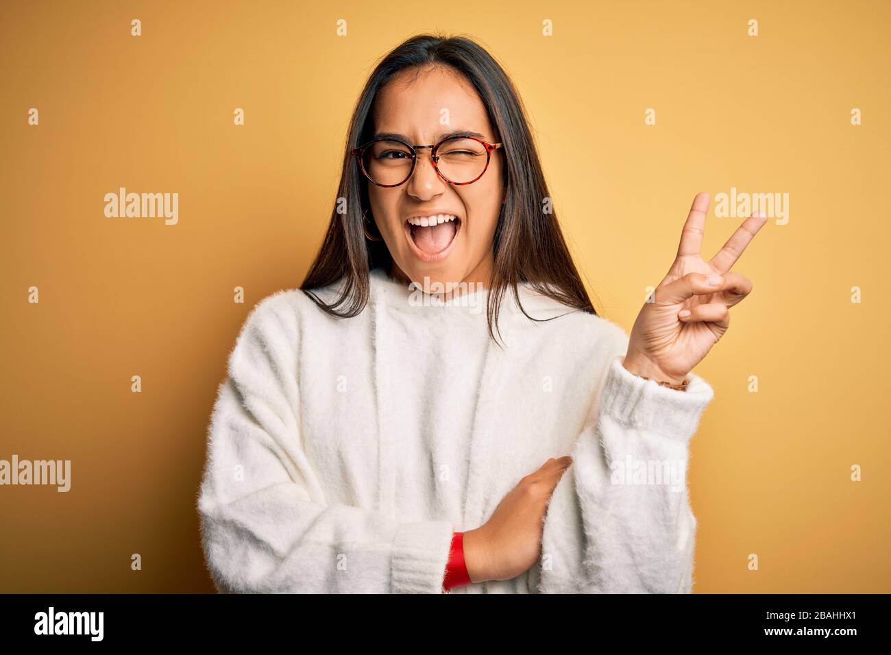 Young beautiful asian woman wearing casual sweater and glasses over ...