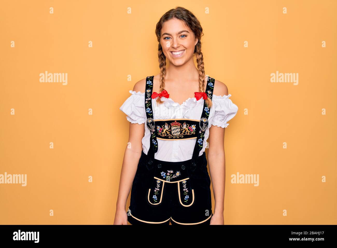 Young beautiful blonde german woman with blue eyes wearing traditional ...