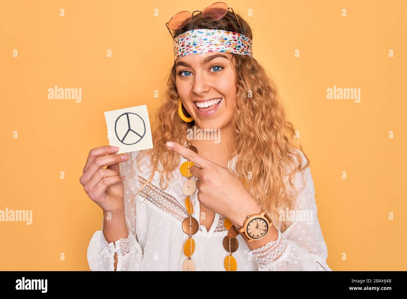 Beautiful hippie woman with blue eyes wearing sunglasses holding ...