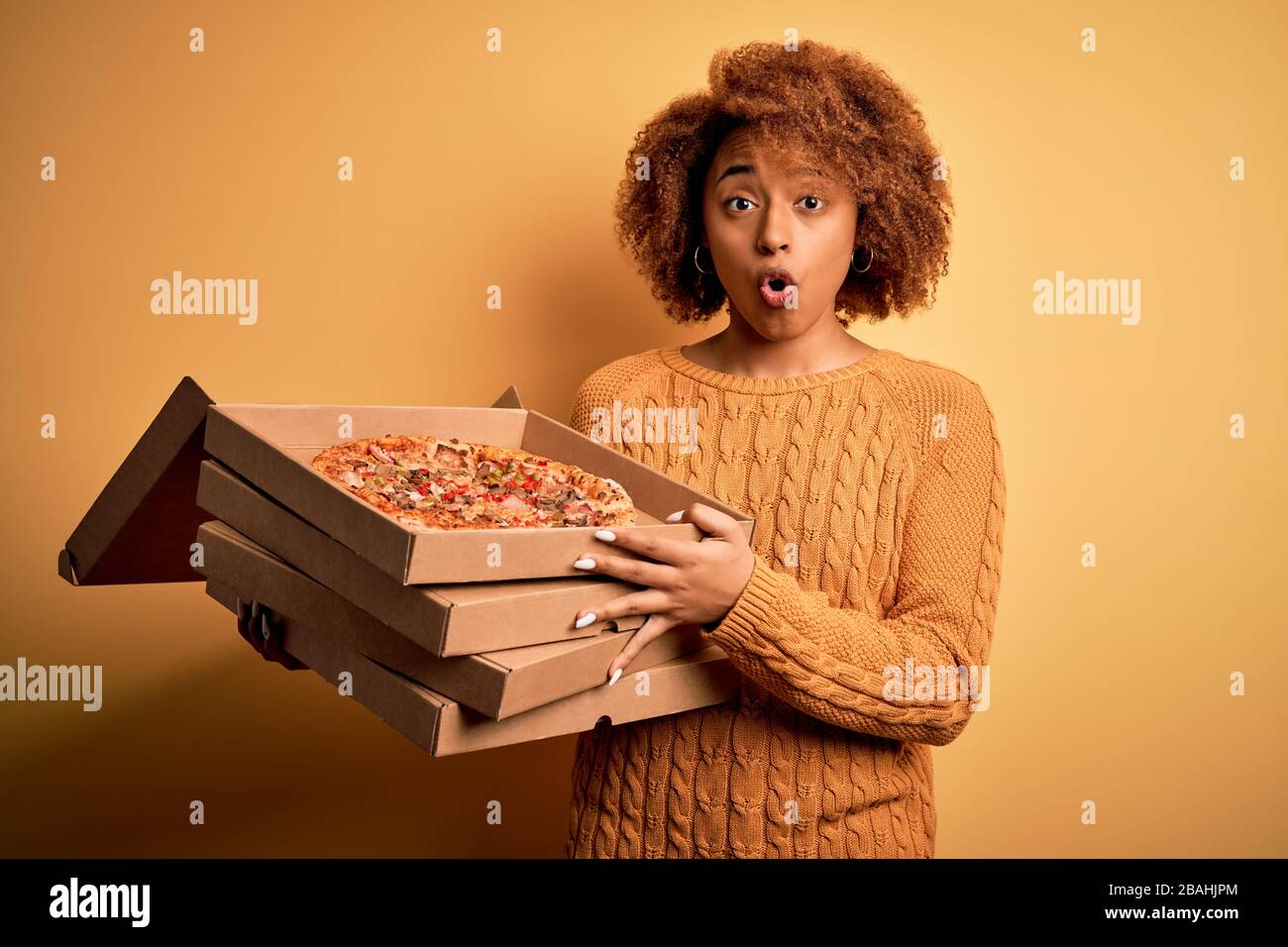 Young African American afro woman with curly hair holding delivery ...