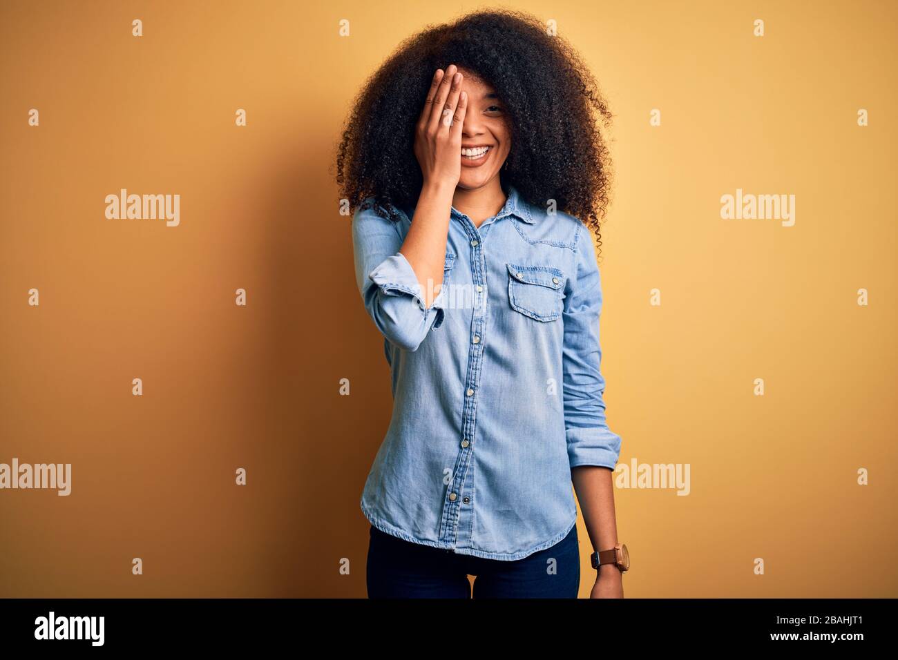 Young beautiful african american woman with afro hair standing over ...