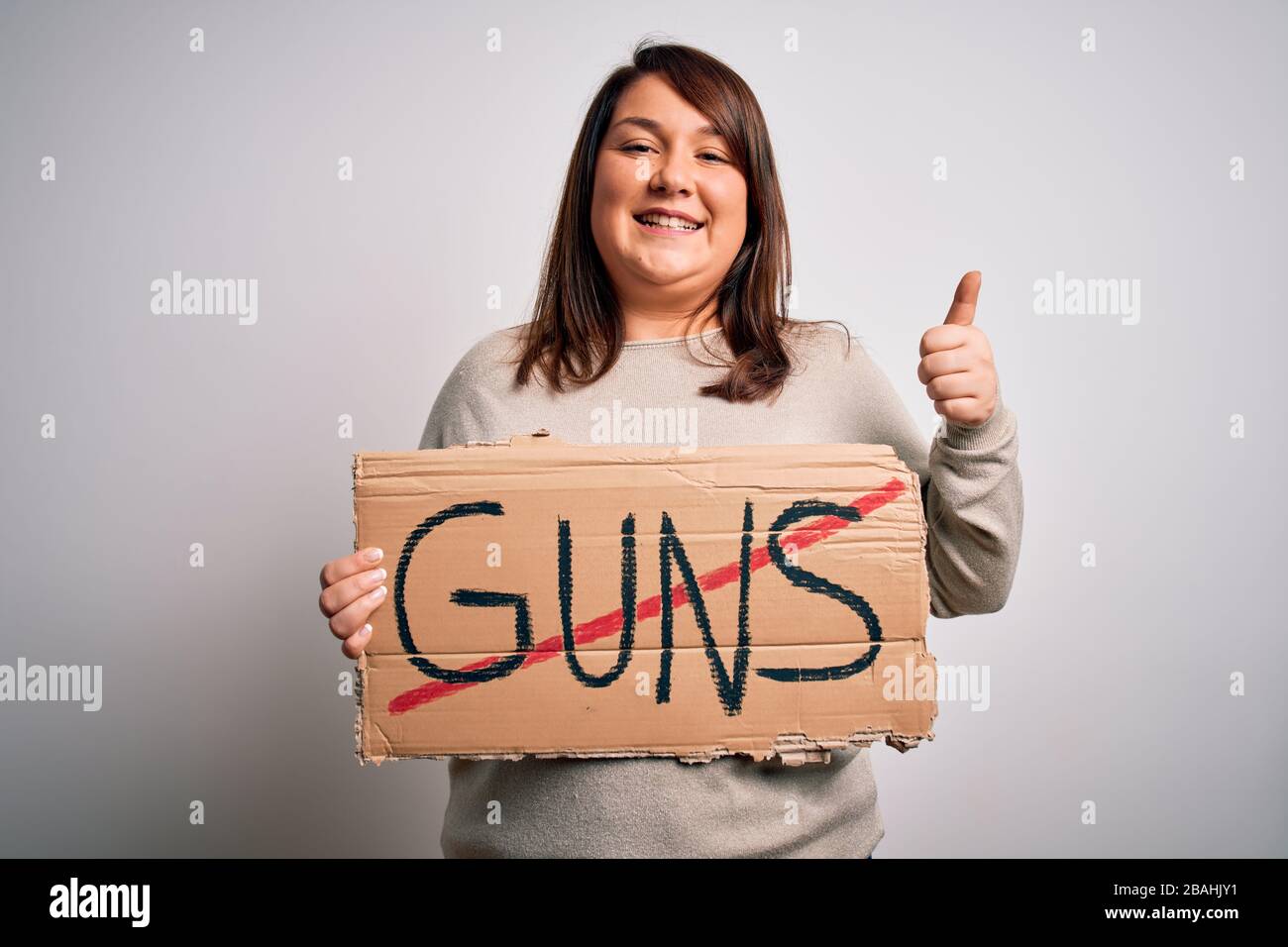 Plus size woman holding stop guns cardboard banner warning about ...