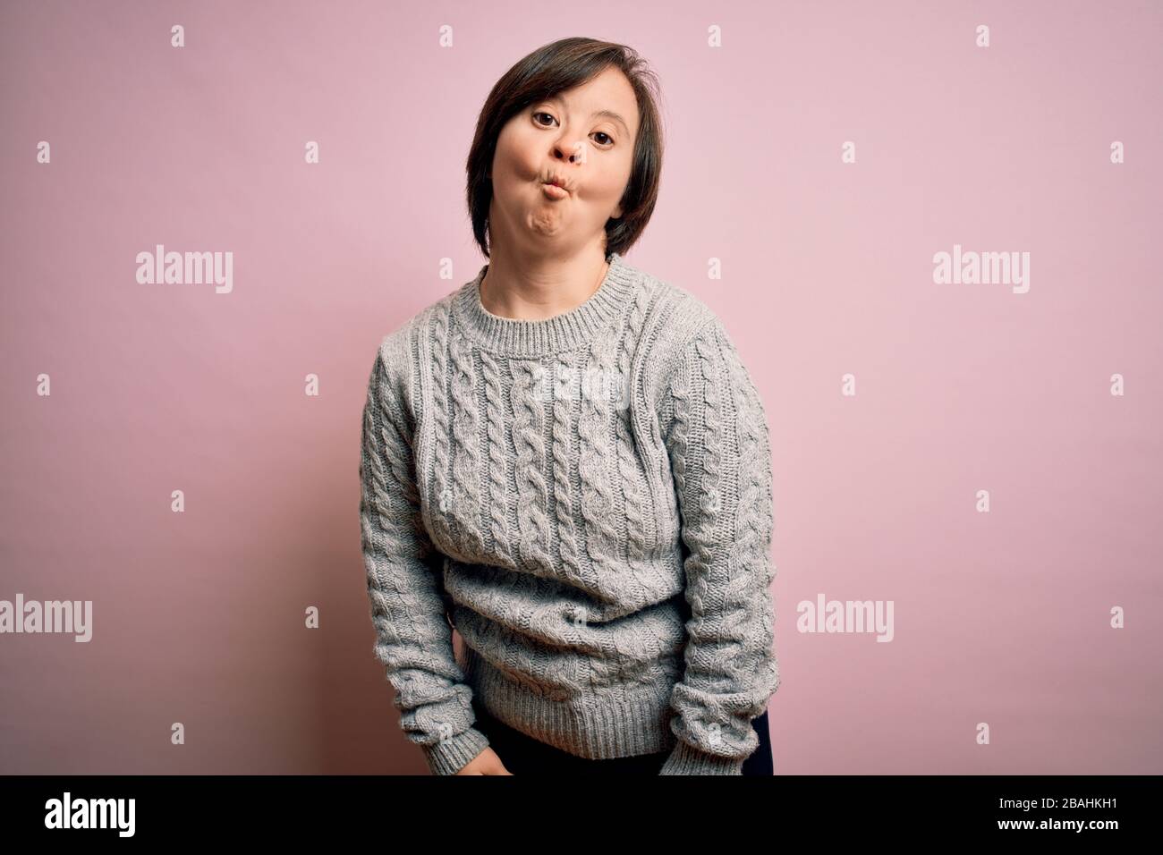 Young down syndrome woman wearing casual sweater over isolated ...